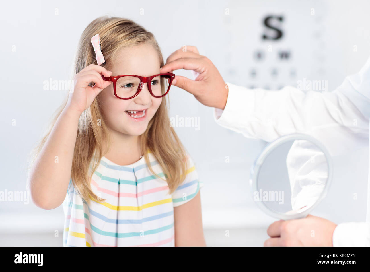 Child at eye sight test. Little kid selecting glasses at optician store ...
