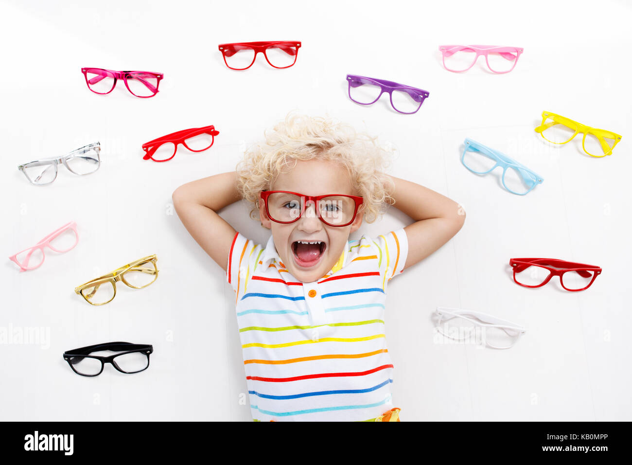 Child at eye sight test. Little kid selecting glasses at optician store ...