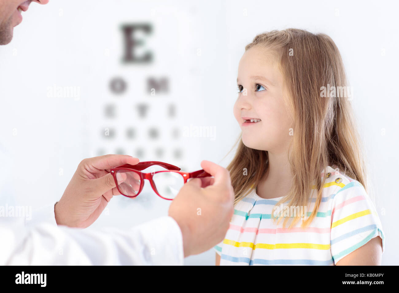 Child at eye sight test. Little kid selecting glasses at optician store ...