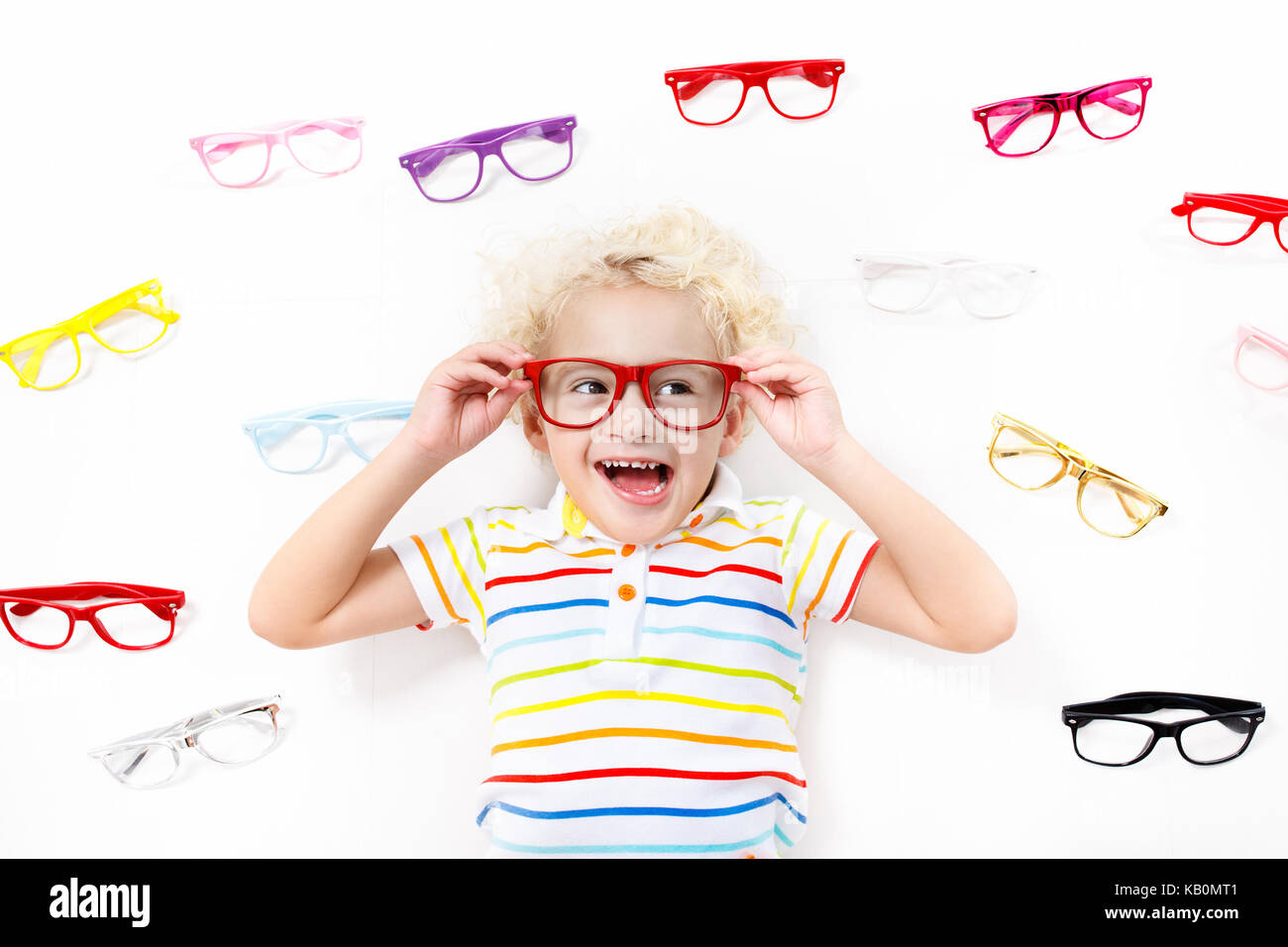 Child at eye sight test. Little kid selecting glasses at optician store ...