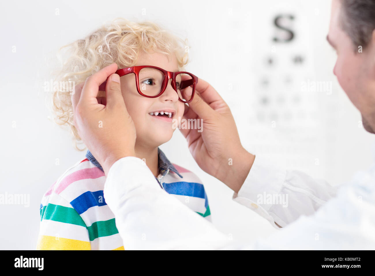 Child at eye sight test. Little kid selecting glasses at optician store ...