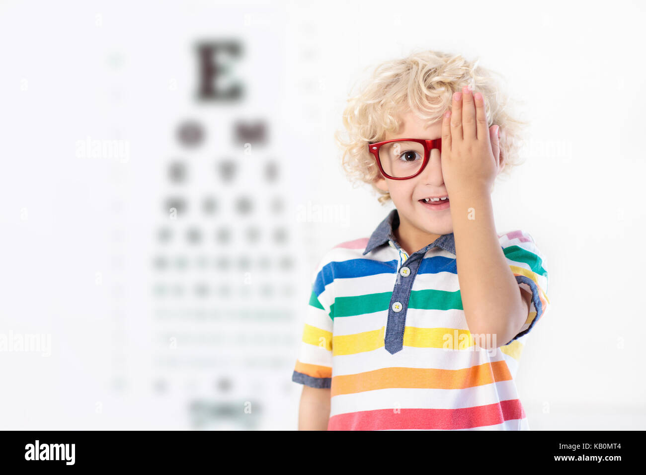 Child at eye sight test. Little kid selecting glasses at optician store ...