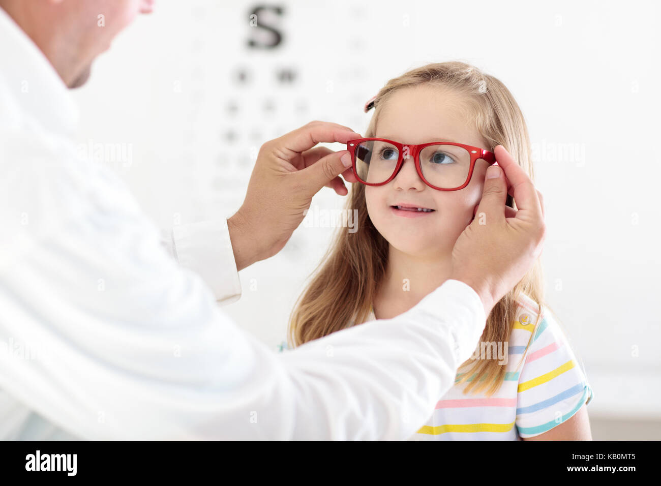 Child at eye sight test. Little kid selecting glasses at optician store ...