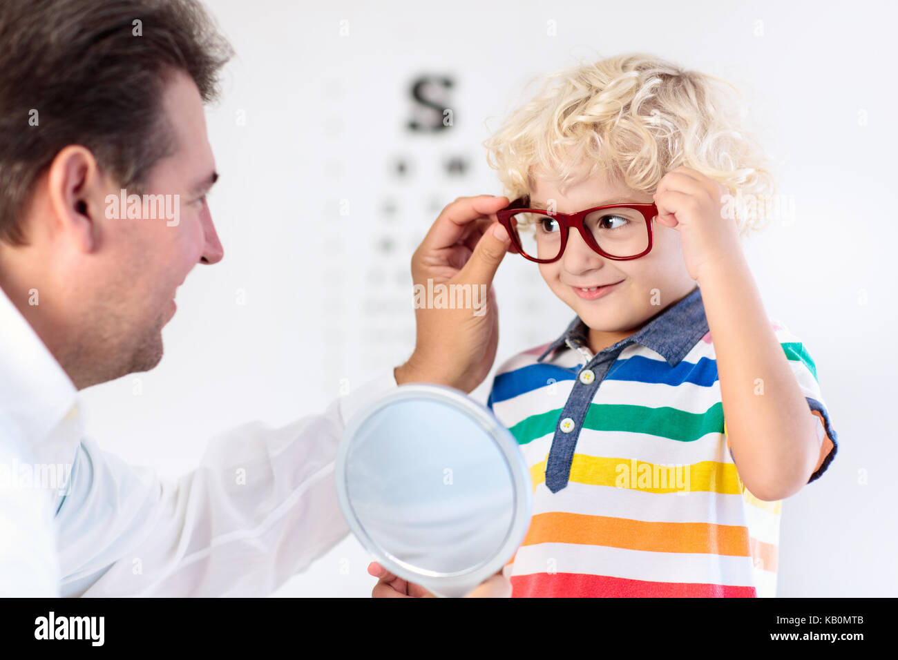 Child at eye sight test. Little kid selecting glasses at optician store ...