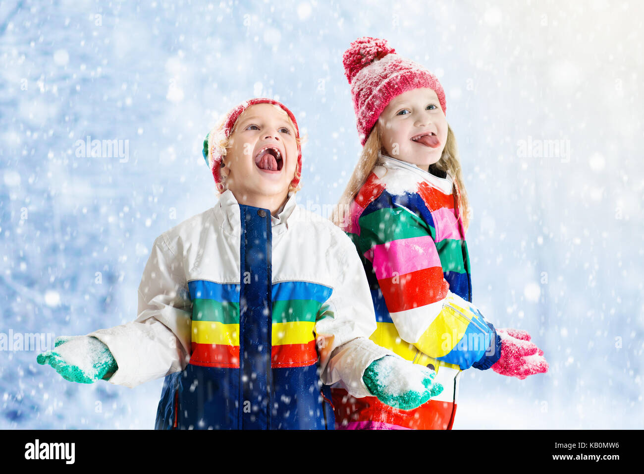 Kids playing in snow. Children play outdoors on snowy winter day. Boy ...