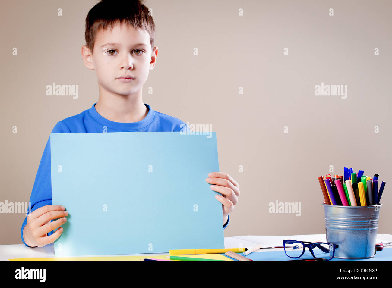 Child making greeting card. Boy holding sheet of colored paper Stock ...