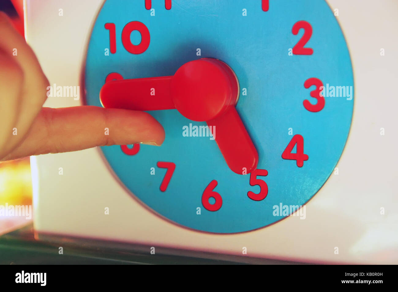 Child adjusting clock. Kids clock toy Stock Photo - Alamy