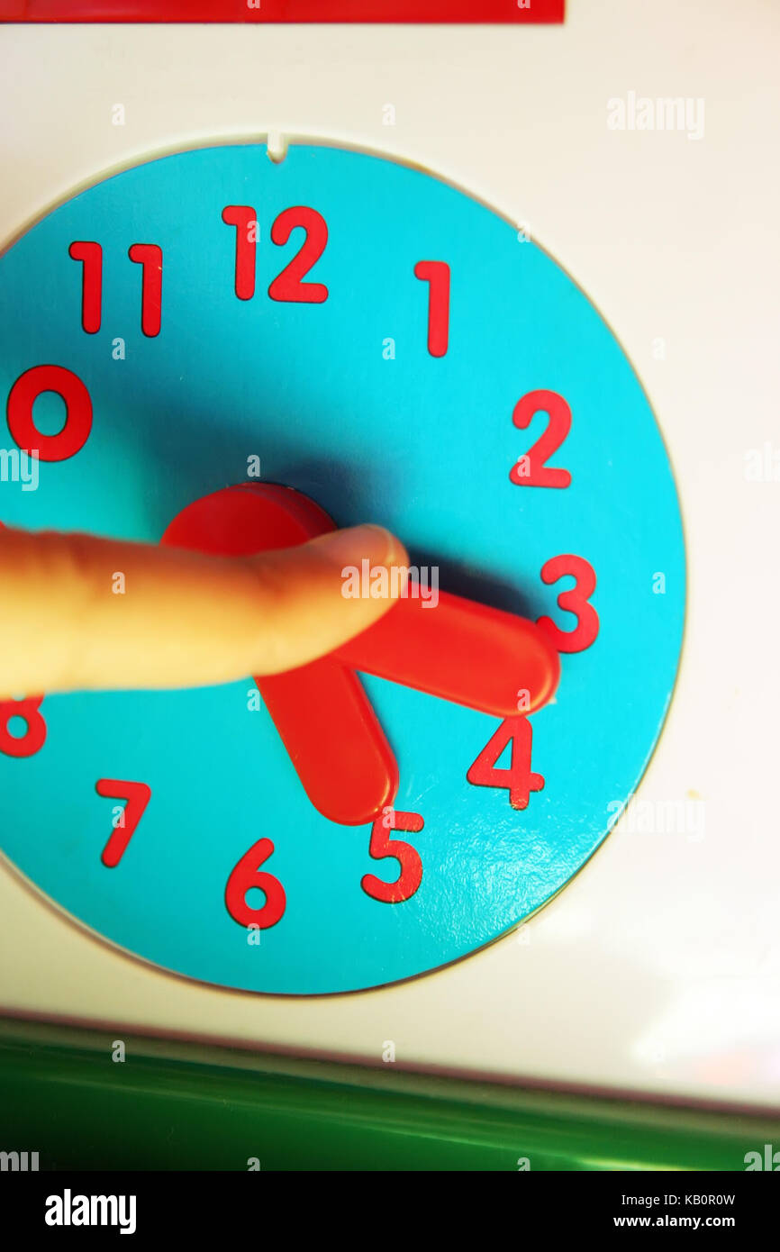Child adjusting clock. Kids clock toy Stock Photo - Alamy