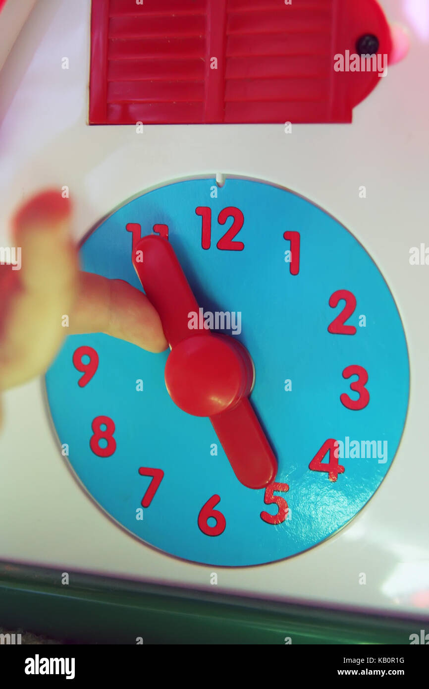 Child adjusting clock. Kids clock toy Stock Photo - Alamy