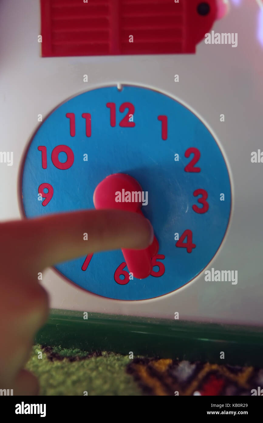 Child adjusting clock. Kids clock toy Stock Photo - Alamy