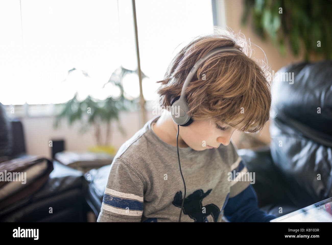 Boy listening to music on headphones Stock Photo - Alamy