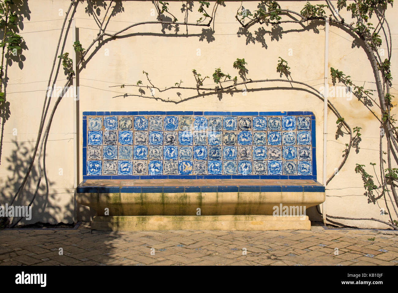Bench decorated with blue handmade spanish tiles with a wall in the ...