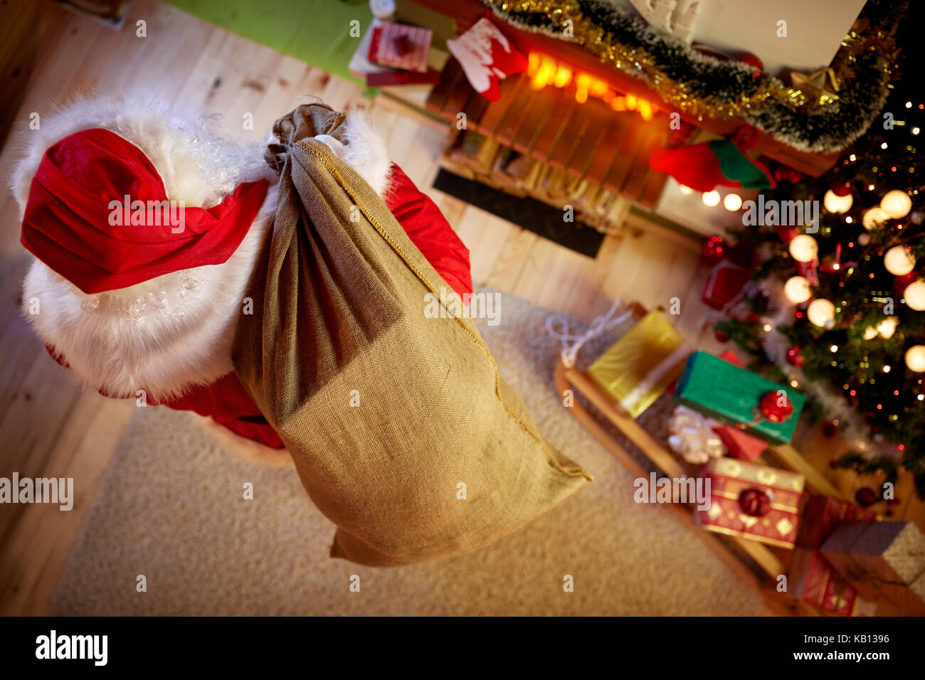 Santa Claus in room with big sack full of Christmas present, top view ...