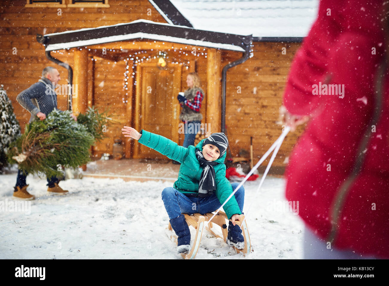 Happy boy sledding at winter time-Family time Stock Photo - Alamy