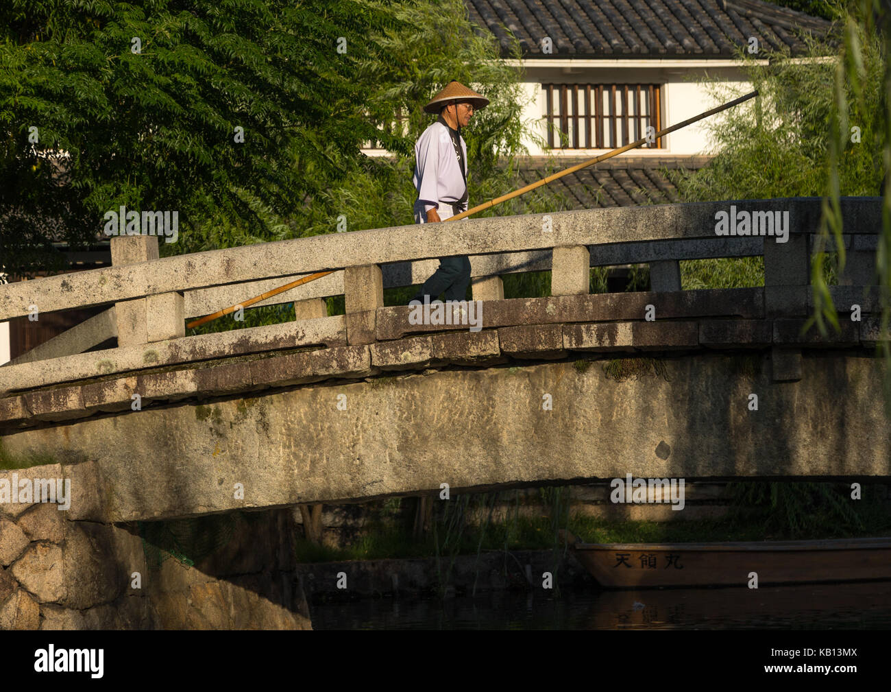 Japanese man in traditional clothing crossing a bridge, Okayama ...