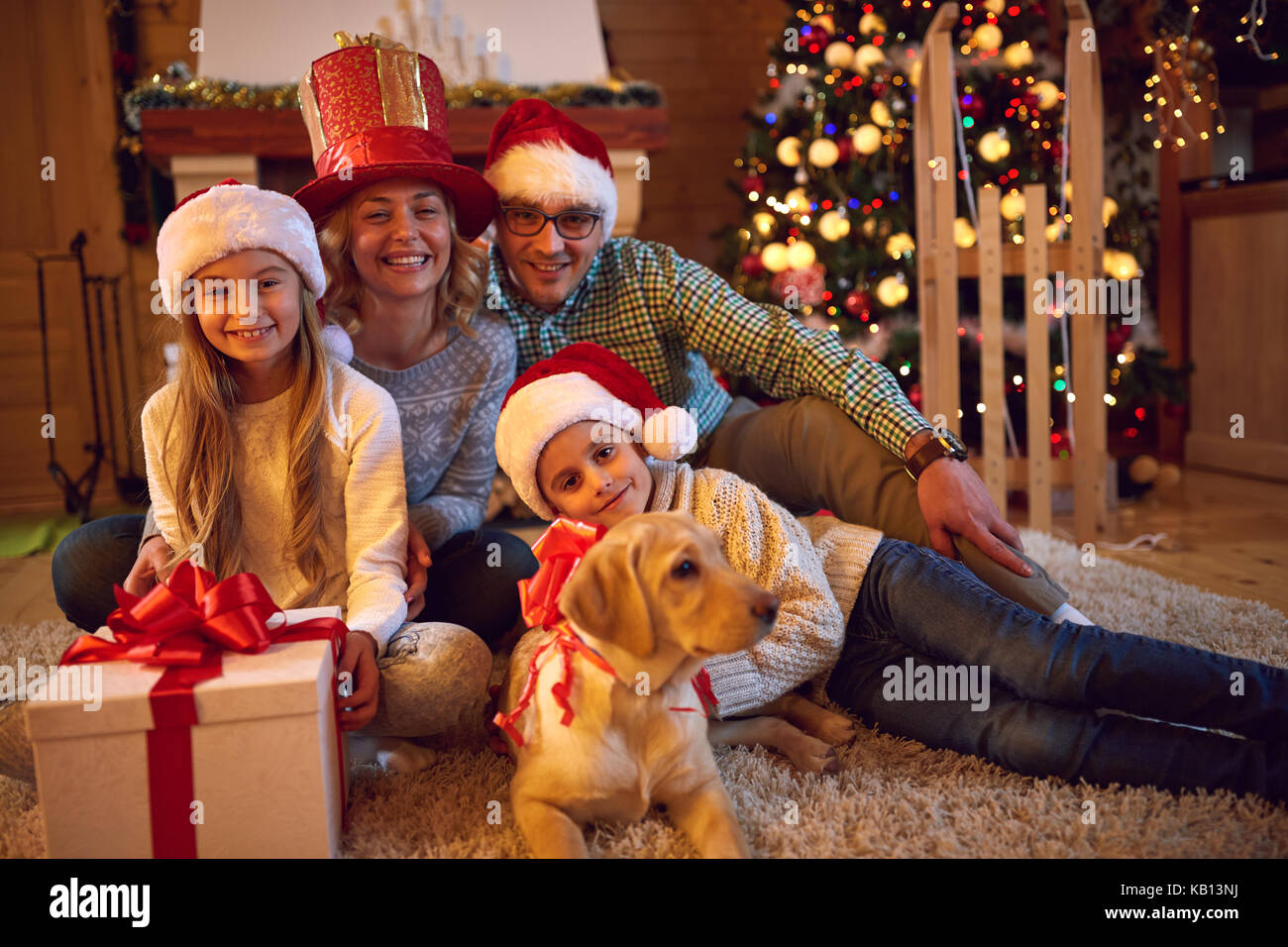 Smiling parents and child with present for Christmas Stock Photo - Alamy