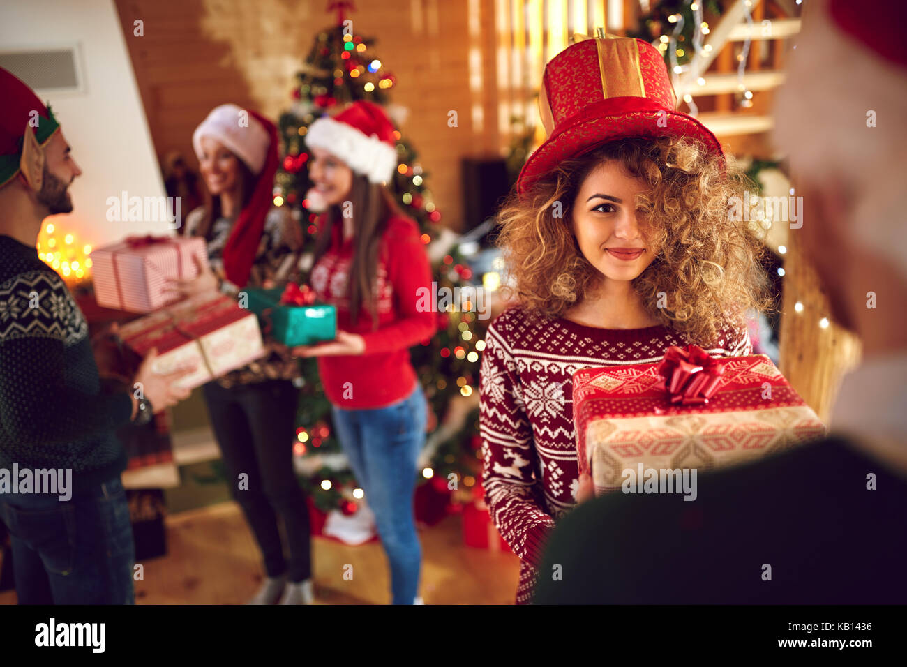 Young people giving presents as surprise for Christmas Stock Photo - Alamy