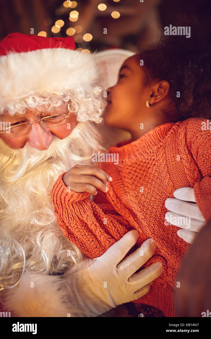 Child whispers her secret to Santa Clause Stock Photo - Alamy