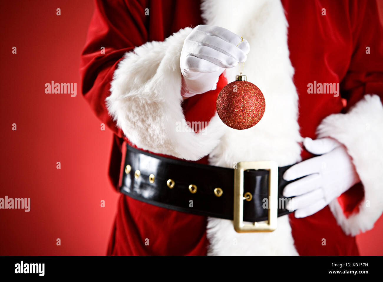Anonymous Santa Claus on a red background holding various props, gifts ...