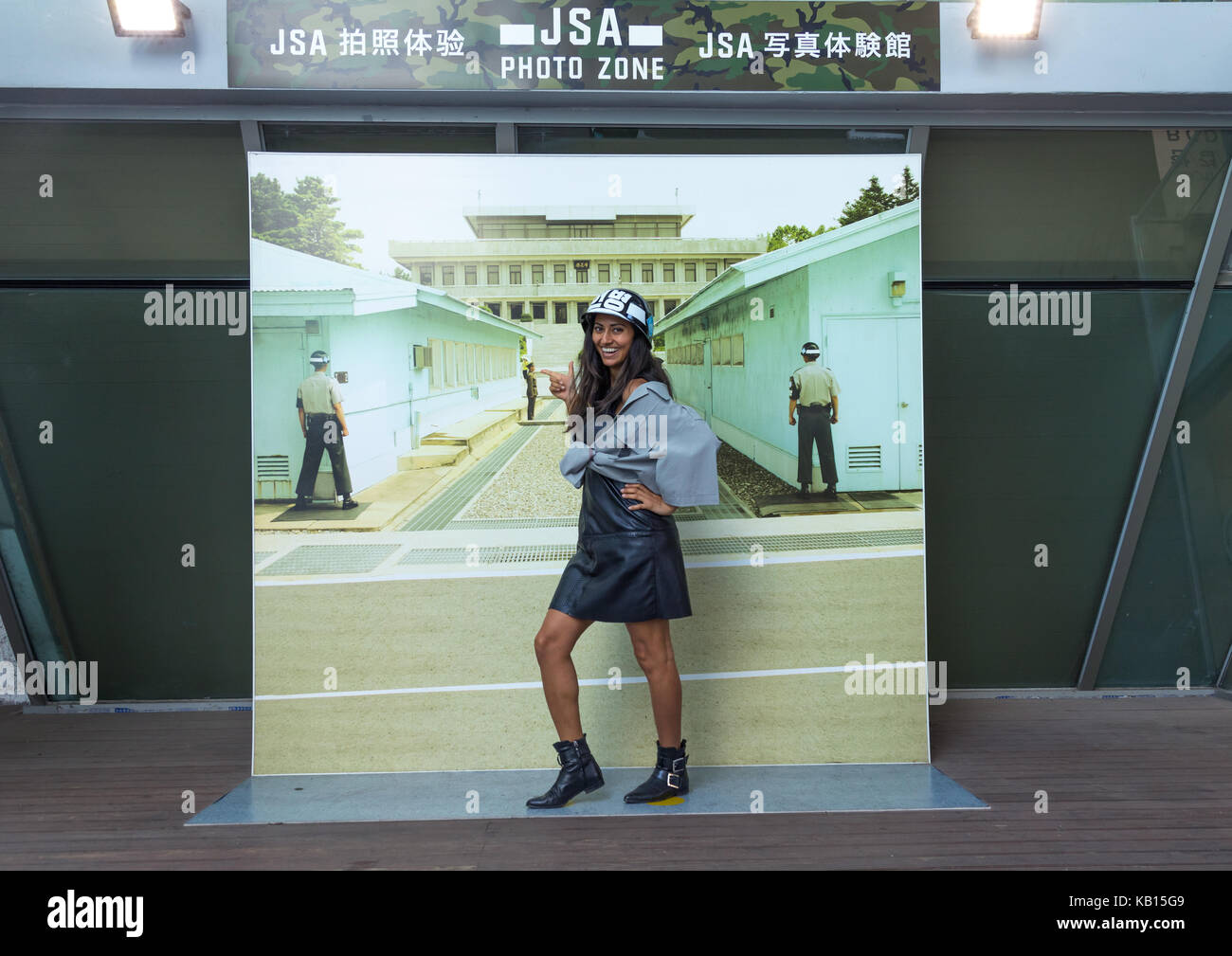 Tourist posing in front of a giant picture of the dmz border, North ...