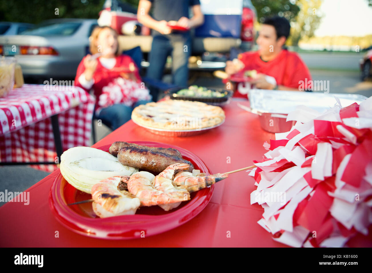 Group of friends doing football tailgating. Cooking food, cheering, etc ...