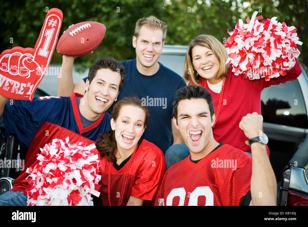 Group of friends doing football tailgating. Cooking food, cheering, etc ...