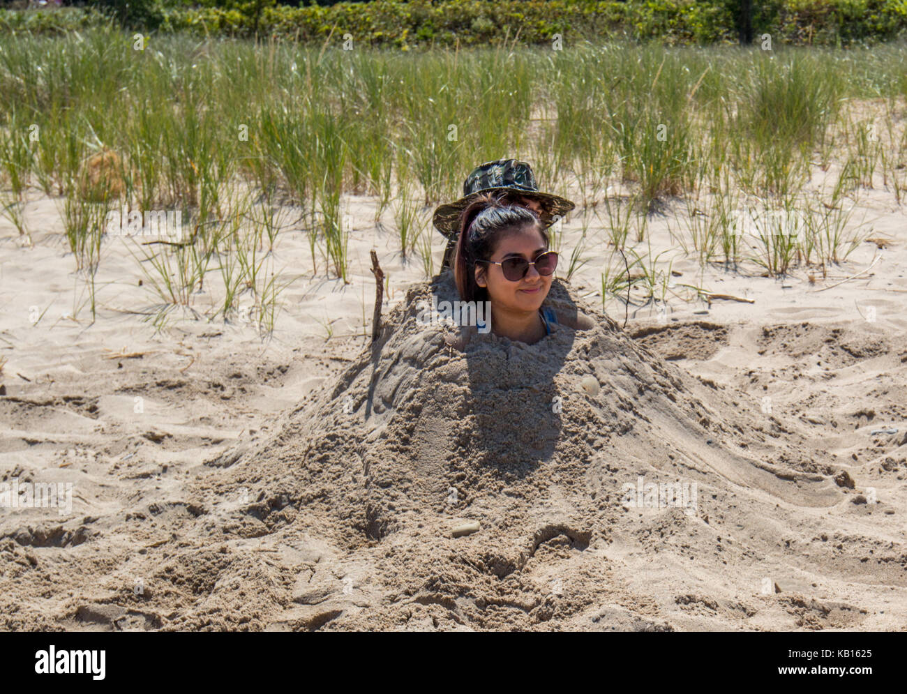 Woman buried in sand beach hi-res stock photography and images - Alamy