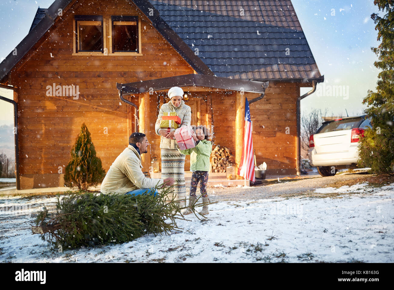 curious girl with parents holding ear on gift box, listens a gift Stock ...