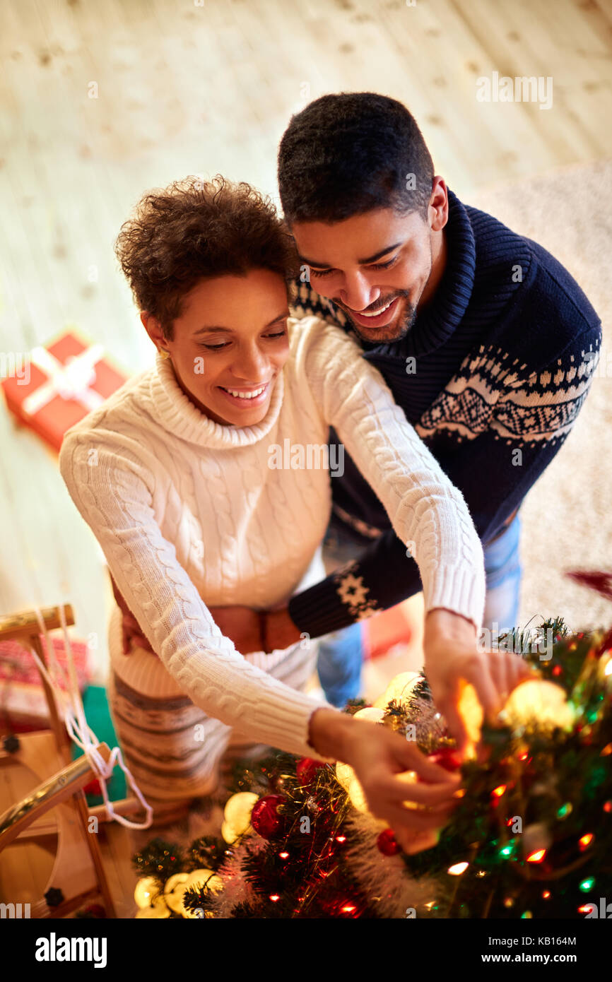 Afro couple in love decorated Christmas tree Stock Photo - Alamy