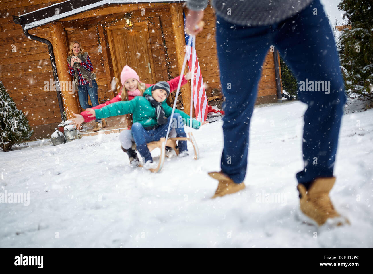 Family enjoying on winter holiday - fun sledding Stock Photo - Alamy