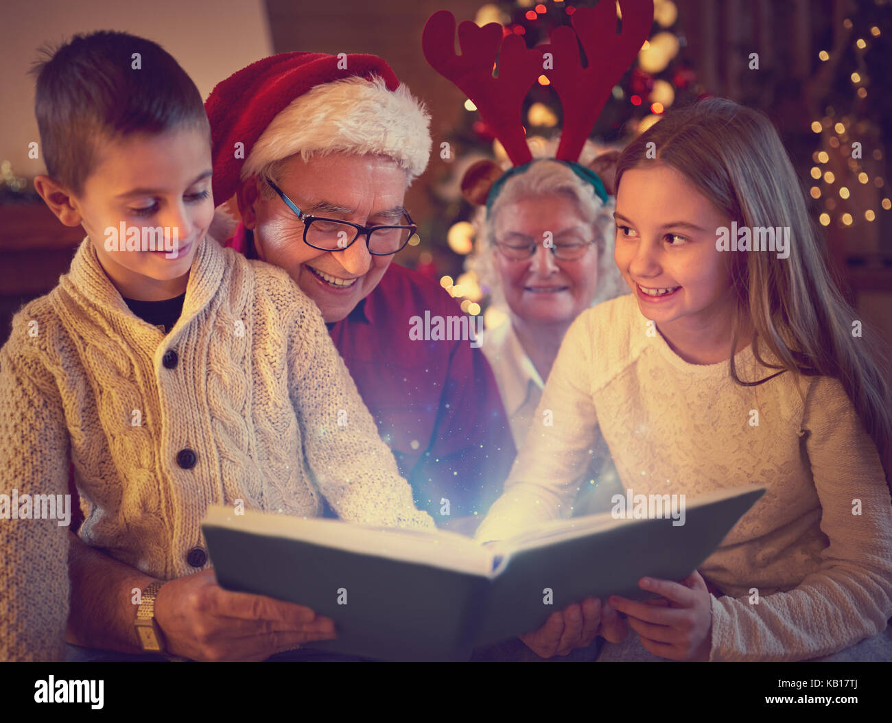 grandparents and grandchildren reading magic xmas book Stock Photo - Alamy