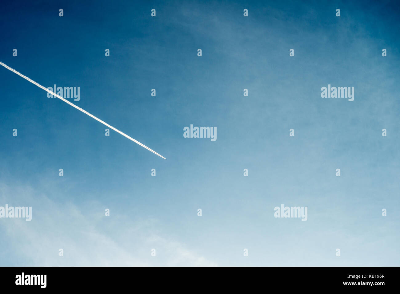 Powder blue sky with a jet and jet stream running diagonally across the ...