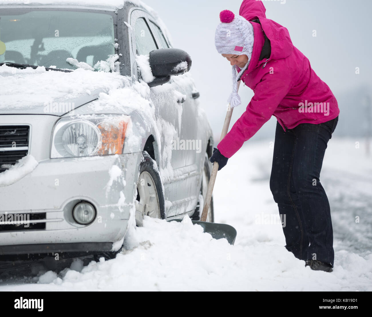 woman with shovel clears snow around the car Stock Photo - Alamy