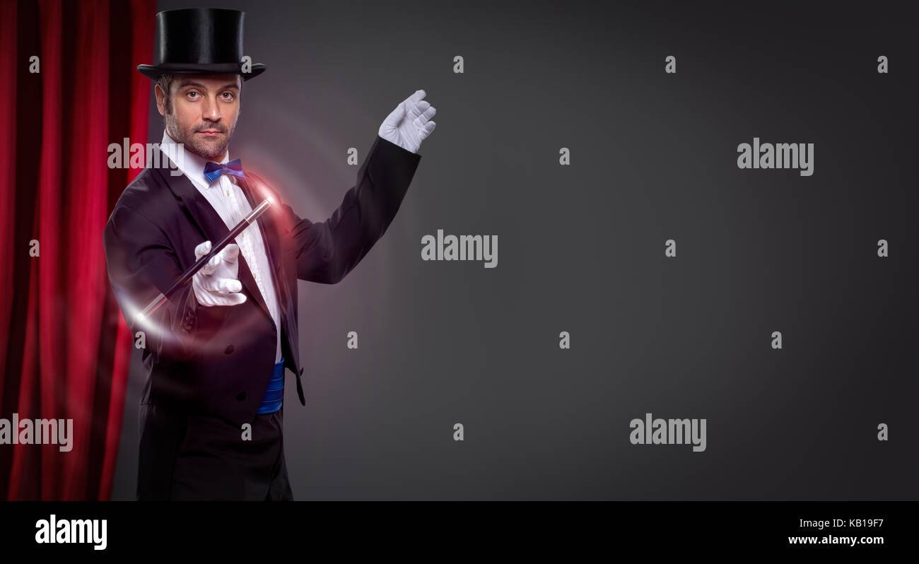 Magician with magic wand in action Stock Photo - Alamy