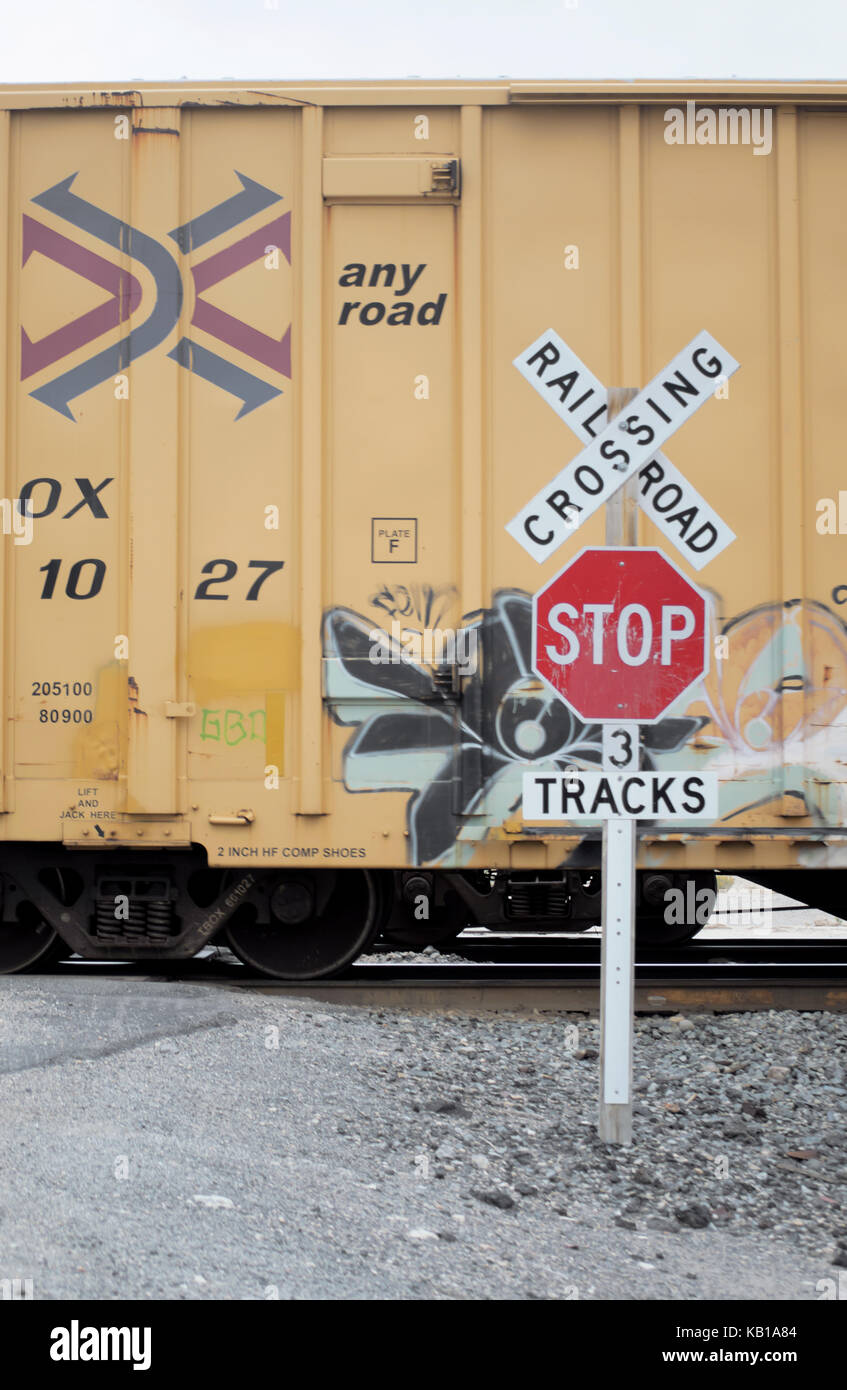 A rail road crossing sign in front of a moving railroad trailer Stock ...