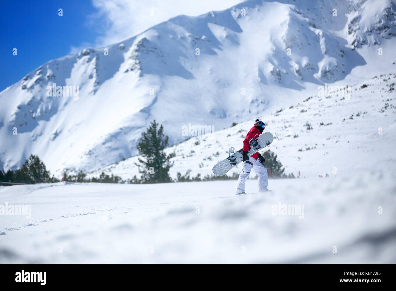 snowboarder climbing up the slope with snowboard Stock Photo - Alamy