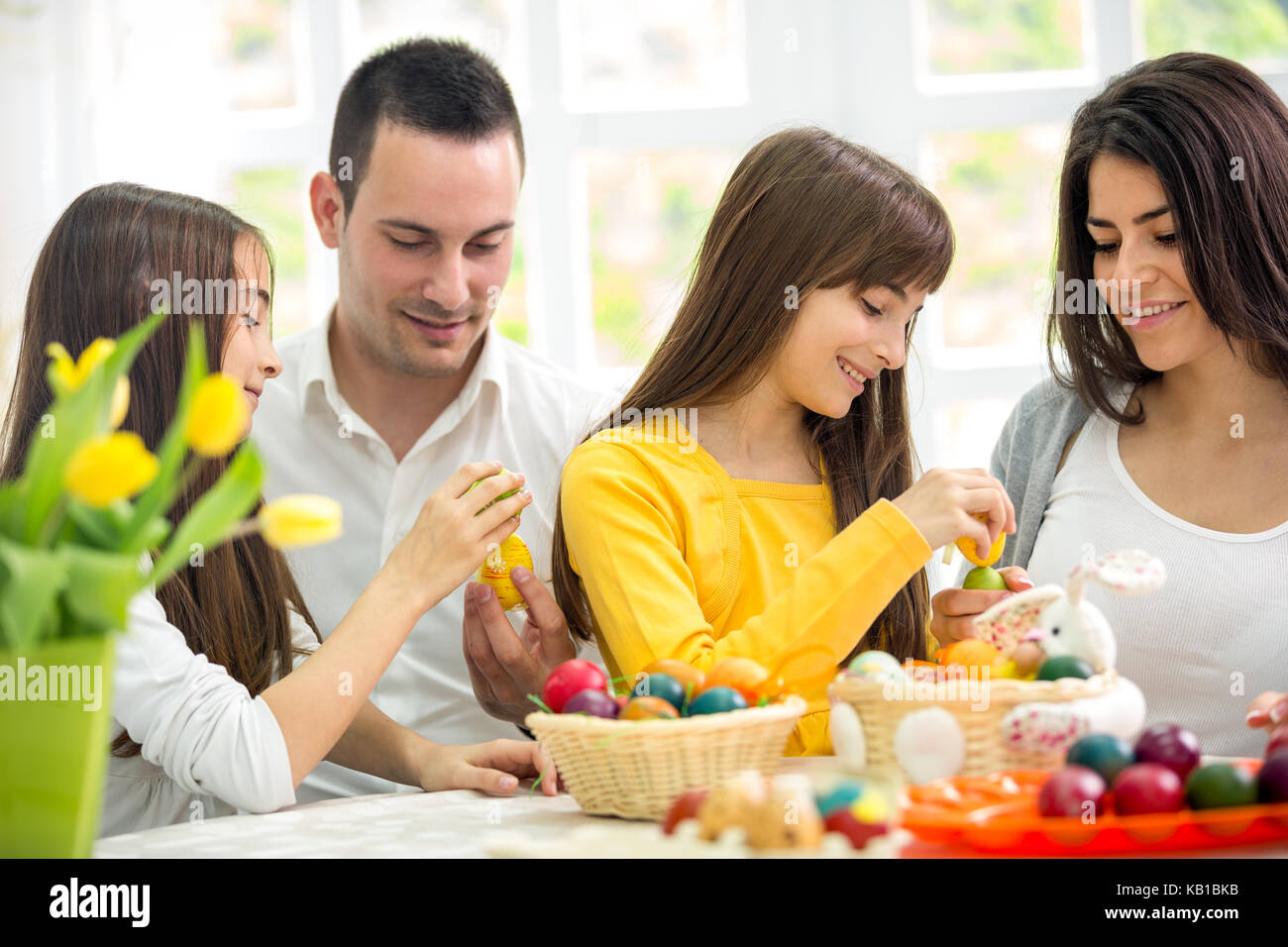 happy family on Easter, parent with two daughters playful with Easter ...