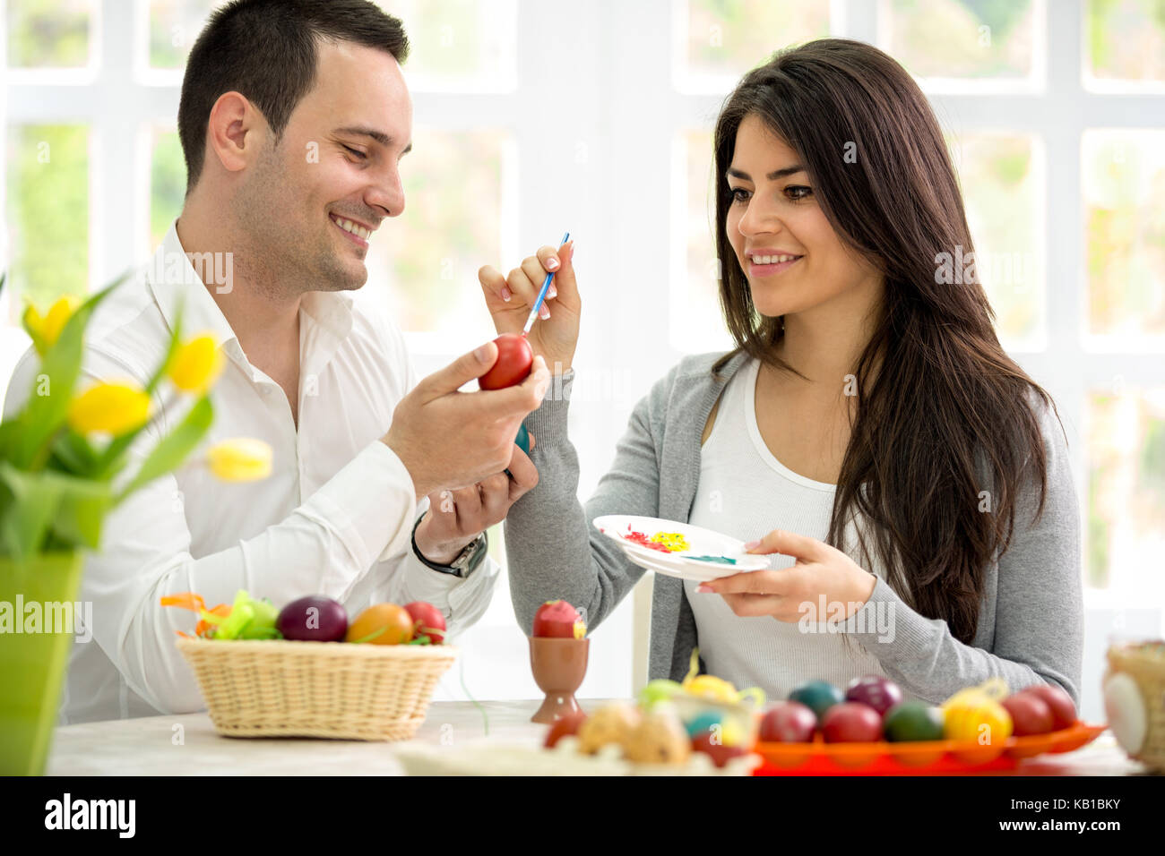 Young man and woman painting Easter eggs, couple in love on Easter ...