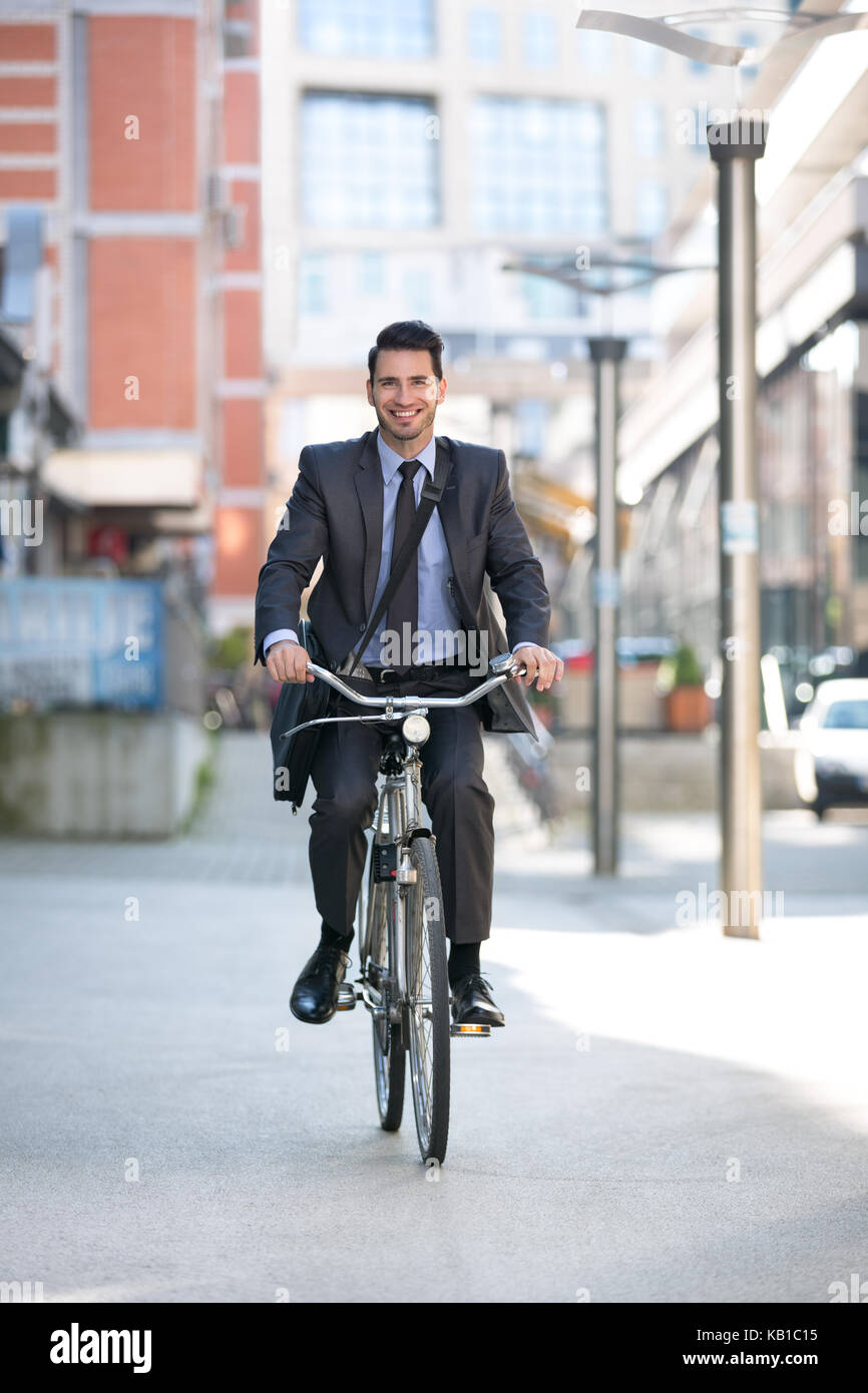 Carefree businessman riding a bicycle outdoors go to work Stock Photo ...