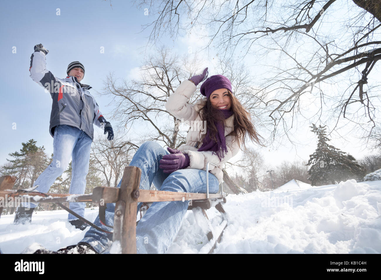 Young man throwing snowball at his girlfriend, fun in snow Stock Photo ...