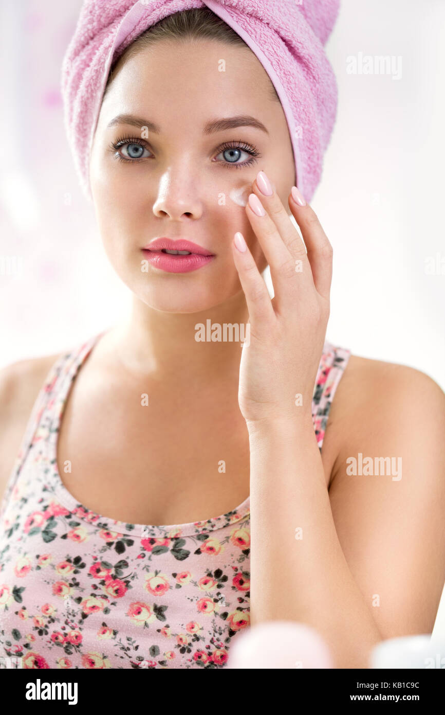 Young girl applying cream on face , skincare Stock Photo - Alamy