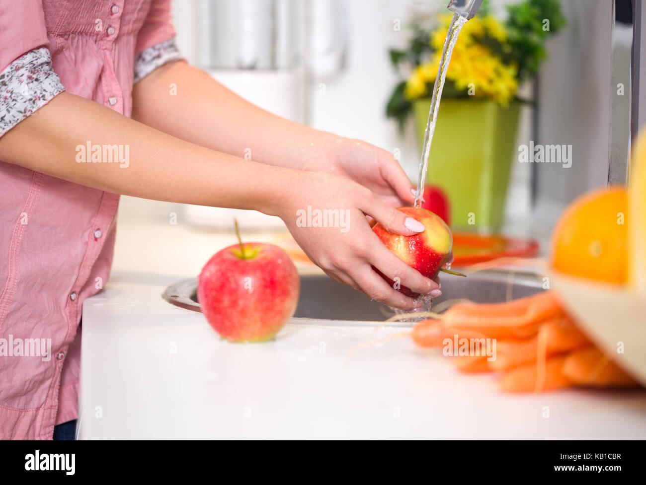 Washing fruit, woman washing red apple under the tap Stock Photo - Alamy