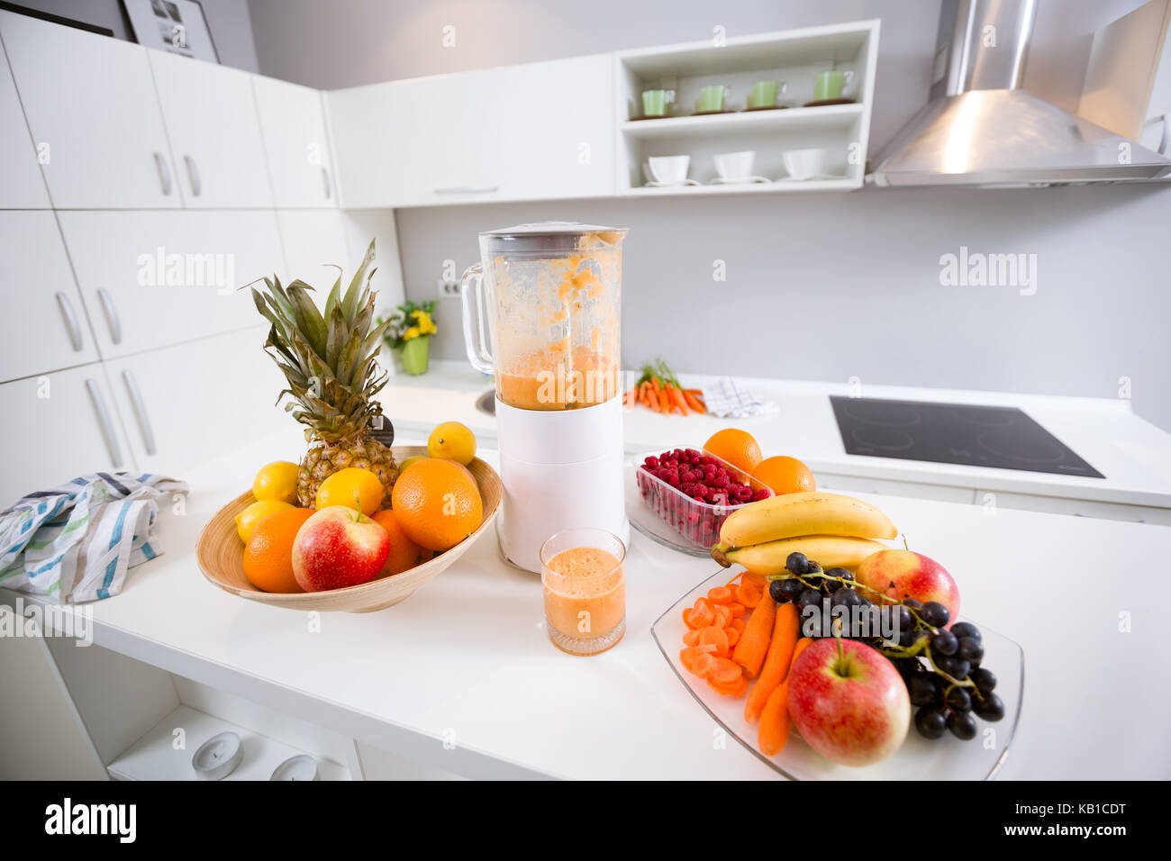 Fresh juice or smoothie in blender machine on the kitchen interior ...