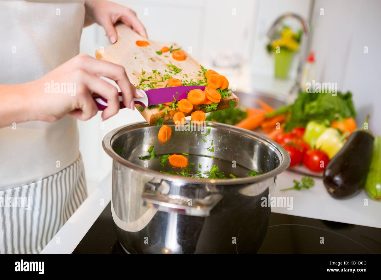 Fresh vegetables on the cutting board are falling in the pot, concept ...