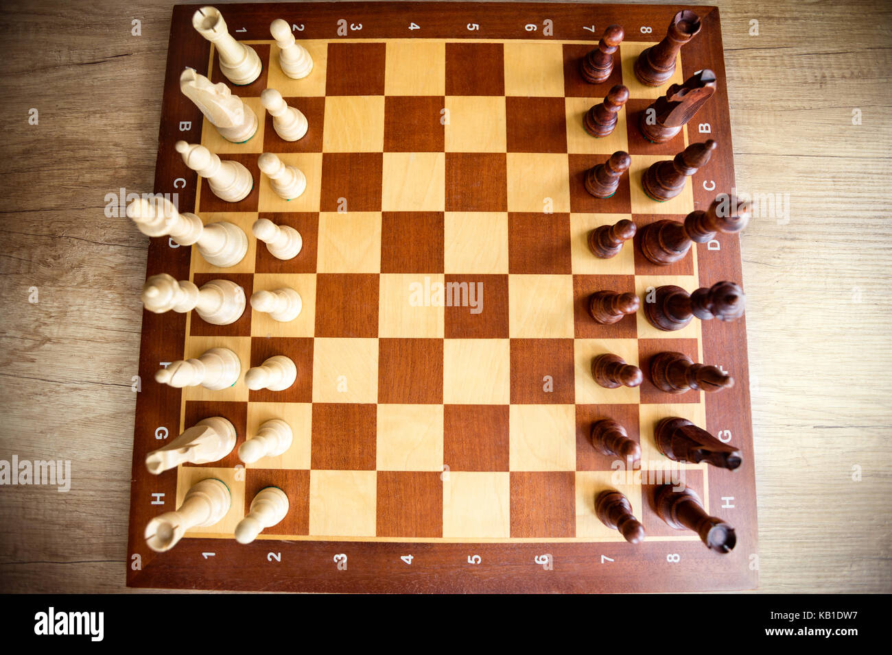 Wooden chess board with figures on wooden table Stock Photo - Alamy