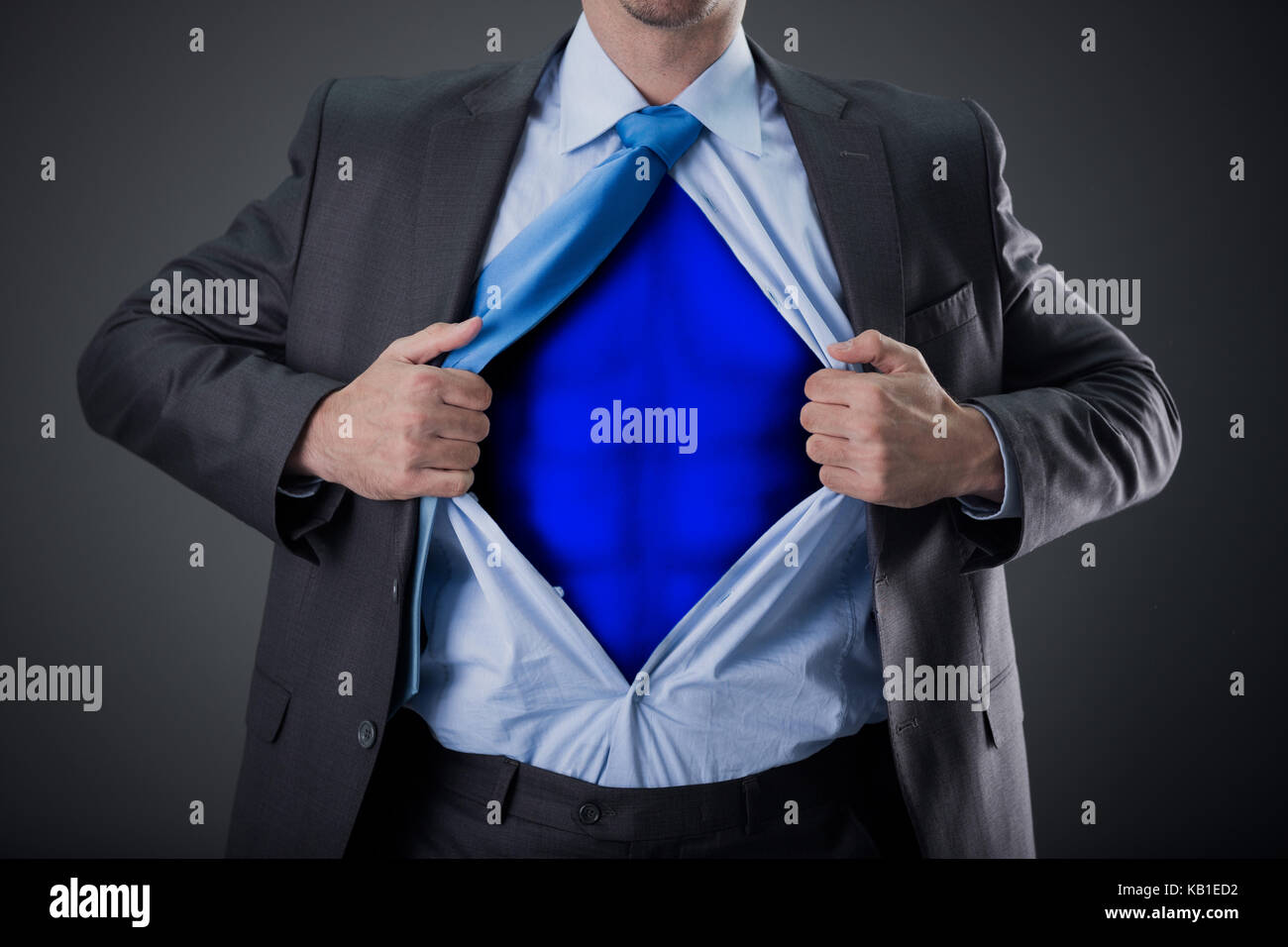 Young businessman acting like a super hero and tearing his shirt off ...