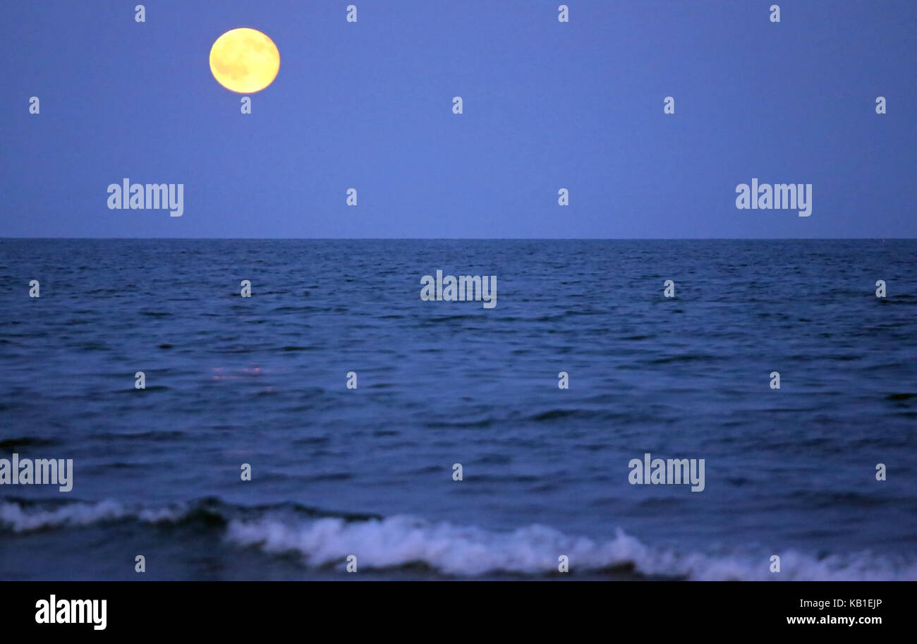 tranquillity scene with big red moon on the sea Stock Photo - Alamy