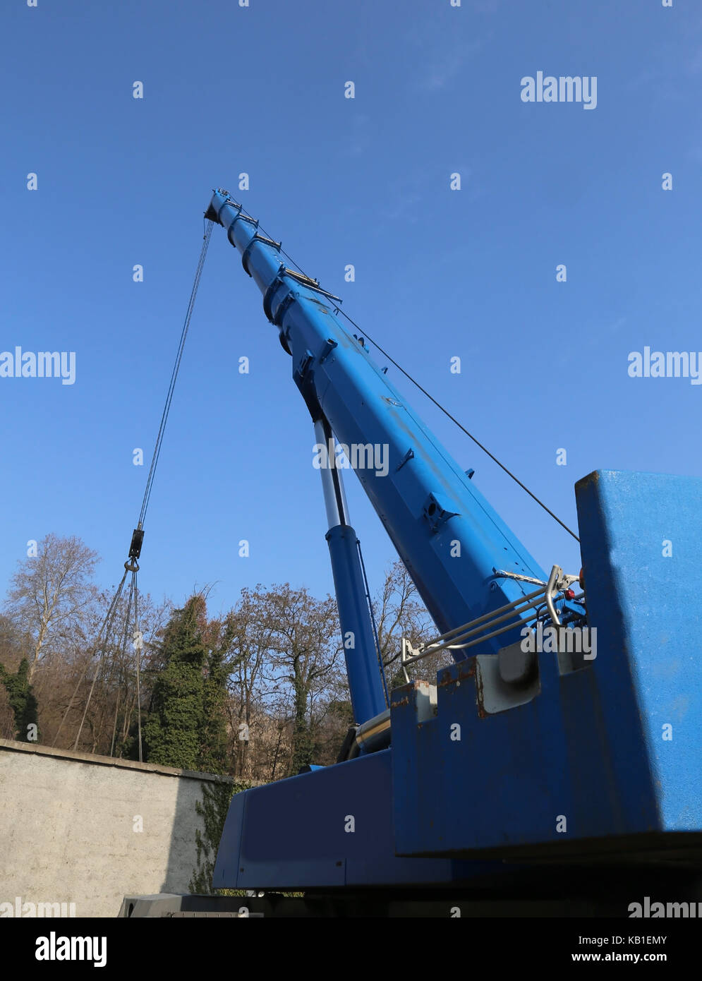 blue hydraulic arm of a powerful crane for lifting heavy loads at an ...