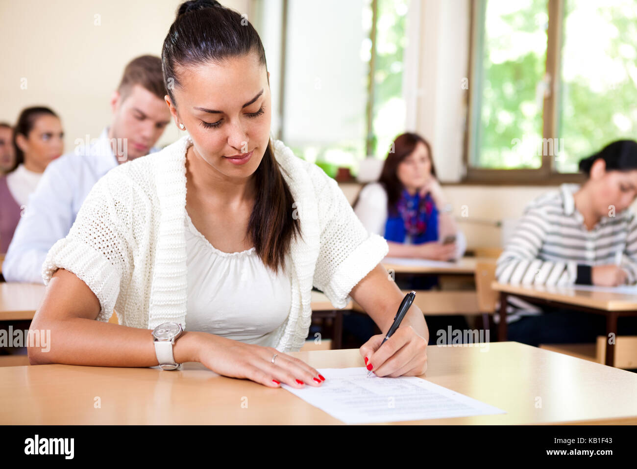 Student woman writing notes in classroom Stock Photo - Alamy