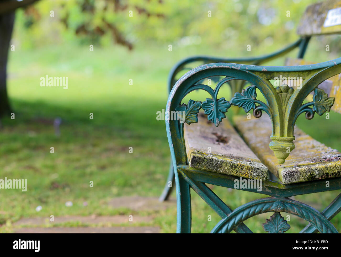 Old turquoise blue painted cast iron garden bench with weathered wooden ...